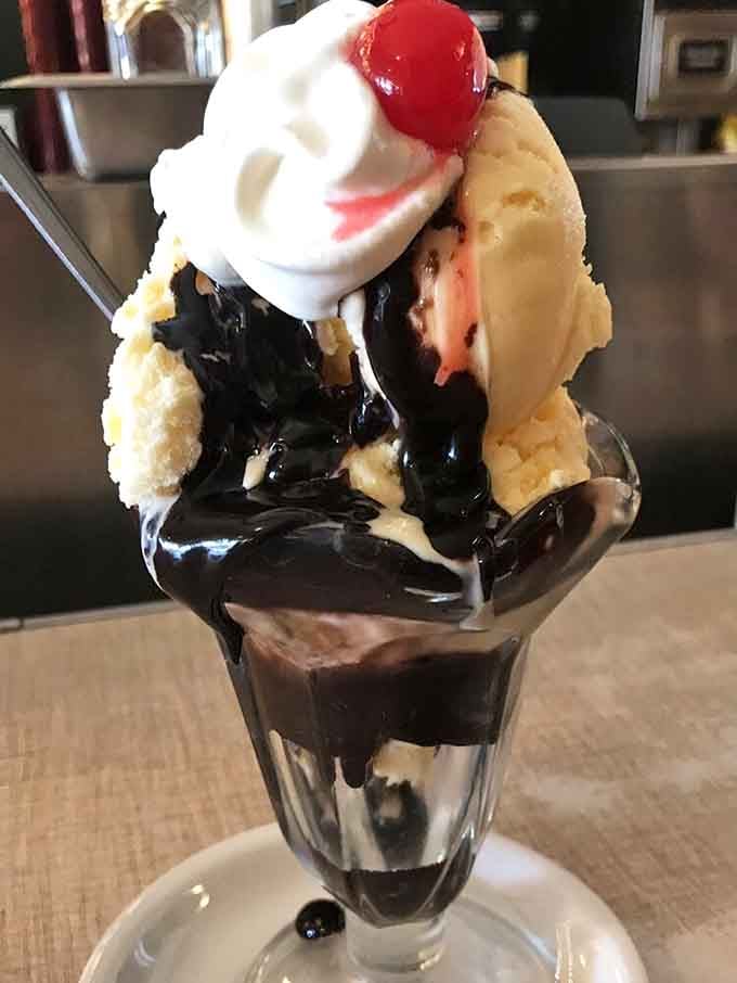 Chocolate sauce, vanilla ice cream, whipped cream, and a cherry create the ultimate sundae that demands your immediate attention.
