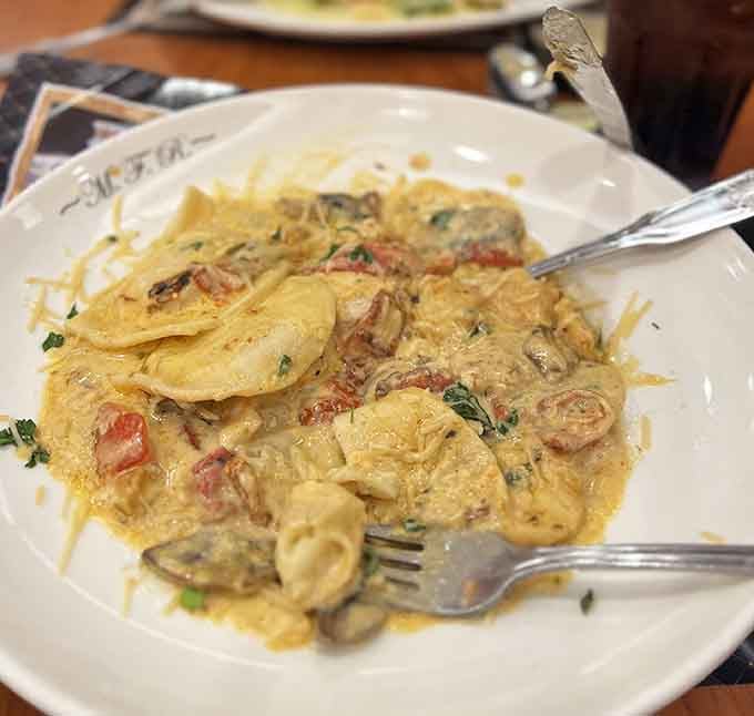 Lobster ravioli swimming in creamy sauce with shrimp, because why choose one seafood when you can have both?