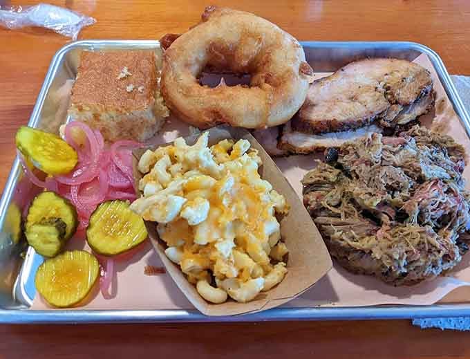 A tray loaded with pulled pork, brisket, onion rings, and mac proves that variety truly is the spice of life.