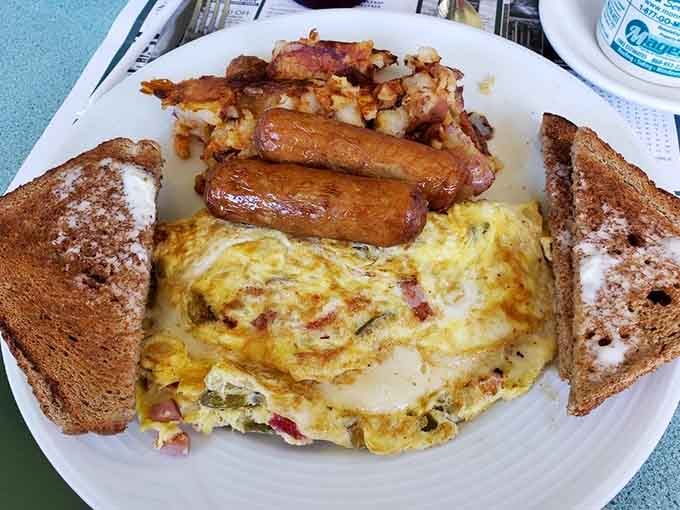 A western omelet so generously stuffed it looks like it's trying to escape the plate, bringing peppers and ham along.
