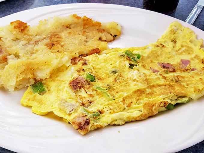 This omelet doesn't just contain ingredients &ndash; it showcases them. A fluffy yellow canvas painted with savory delights and home fries.