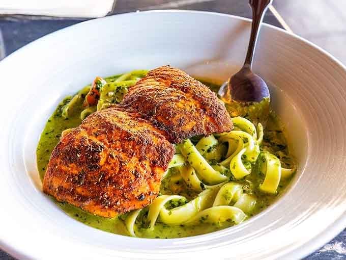 Perfectly seared salmon nestled in vibrant green pasta creates a dish that's as beautiful as it is delicious.