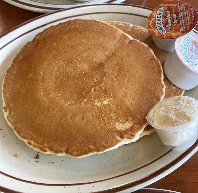 Pancakes so perfectly golden they deserve their own spotlight. The butter pat melts like your resolve to eat sensibly.