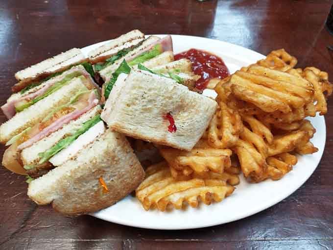Triple-decker club sandwich with waffle fries&mdash;because sometimes more really is more, and that's perfectly fine.