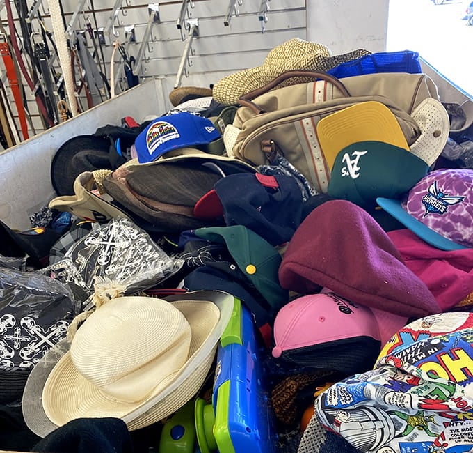 Baseball caps, sun hats, and everything in between create a colorful mountain of headwear waiting for new owners.