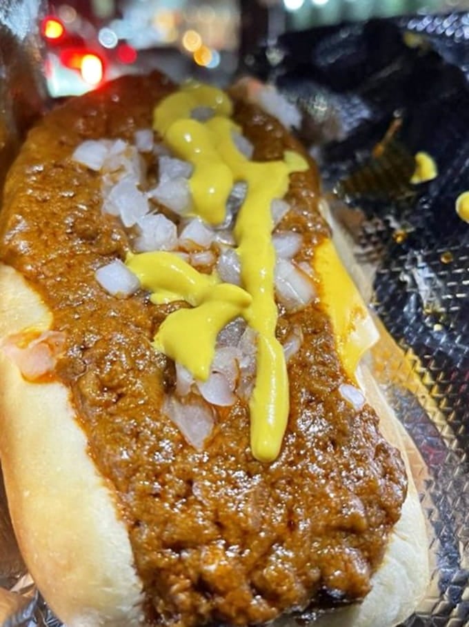 That thick blanket of chili and cheese transforms a simple hot dog into a full-contact eating experience.