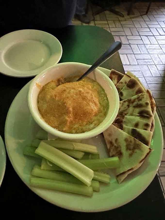 Warm buffalo chicken dip with pita bread: the kind of appetizer that starts friendly debates over sharing.
