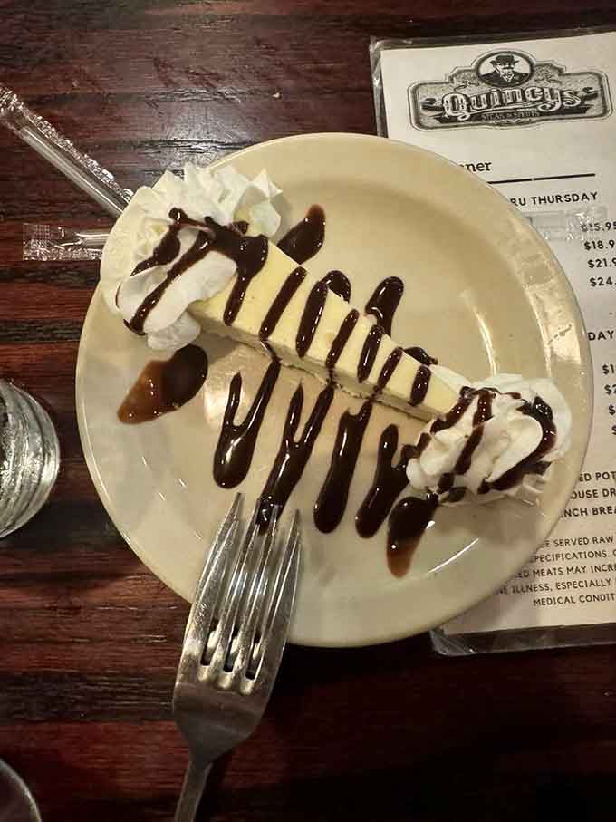 Cheesecake drizzled with chocolate in artistic swirls, proving that dessert here is taken just as seriously as dinner.