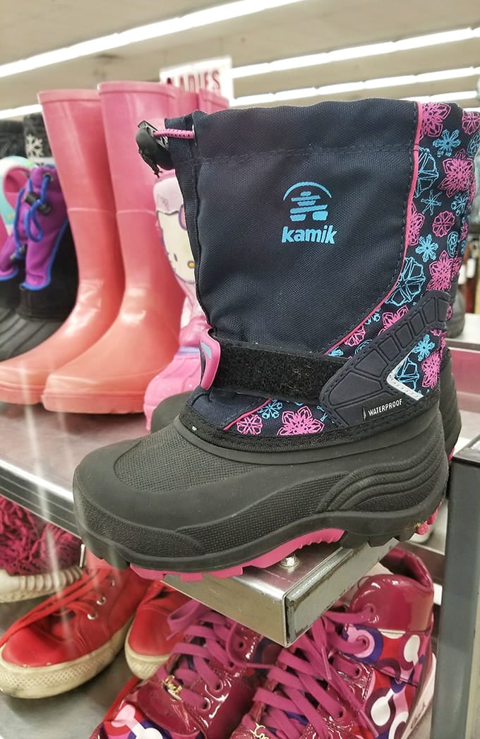 Winter boots that actually work sit next to pink rain boots, because practical and whimsical can absolutely share shelf space.