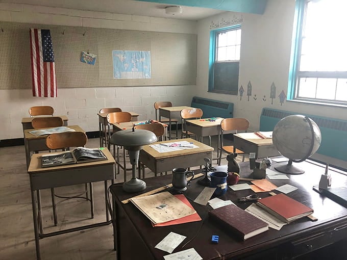 This preserved classroom, complete with American flag and vintage desks, shows how residents received education within the facility walls.