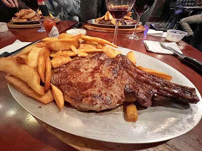 The Cowboy steak arrives looking like it bench-presses smaller cuts of meat, flanked by golden fries that know their supporting role.