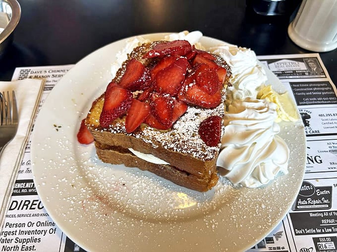 French toast that's crossed the border into dessert territory, crowned with fresh strawberries and enough whipped cream to make a cloud jealous.