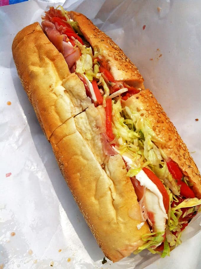 The hero we deserve: sesame-seeded bread cradling a perfect balance of Italian meats, cheese, and veggies. No cape required, just extra napkins.