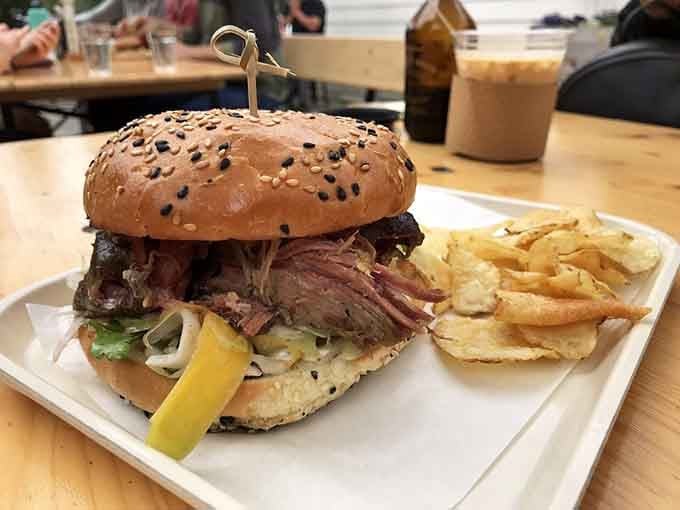 That sesame-studded bun is working overtime to contain all that smoky, succulent pulled pork perfection.