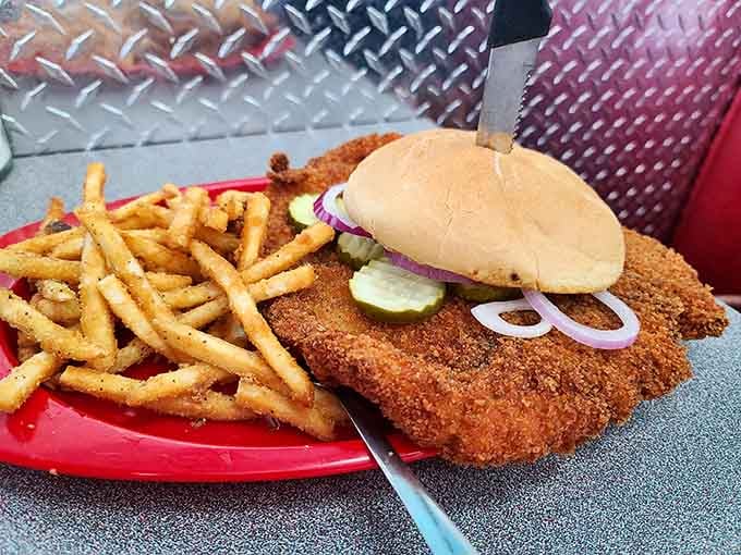 Iowa's unofficial state dish: the breaded pork tenderloin sandwich that refuses to acknowledge the boundaries of its bun. Magnificent excess.