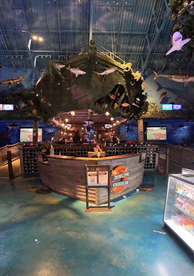 The check-in desk doubles as a shipwreck prop, making lane assignments feel like receiving treasure map coordinates.