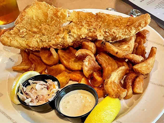 Crispy walleye with a mountain of curly fries and tangy coleslaw, like a fish fry went to heaven.