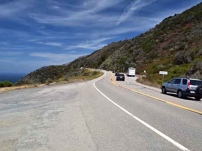 Cars pause along this stretch not for traffic, but because some views demand a moment of silent appreciation.