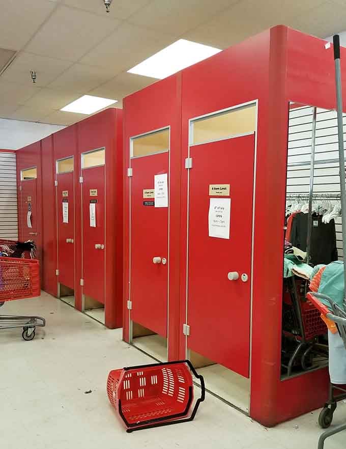 The red fitting room doors stand like sentinels, witnessing countless fashion transformations and "does this still fit?" moments.
