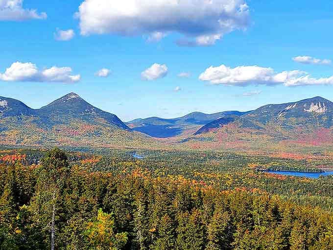 The panoramic view showcases Maine's mountains in their autumn glory. Nature's color palette turned up to eleven.