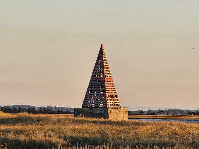 Rising from the golden marshland like a coastal pyramid, this wooden landmark serves as both navigational beacon and conversation piece for curious beachgoers.