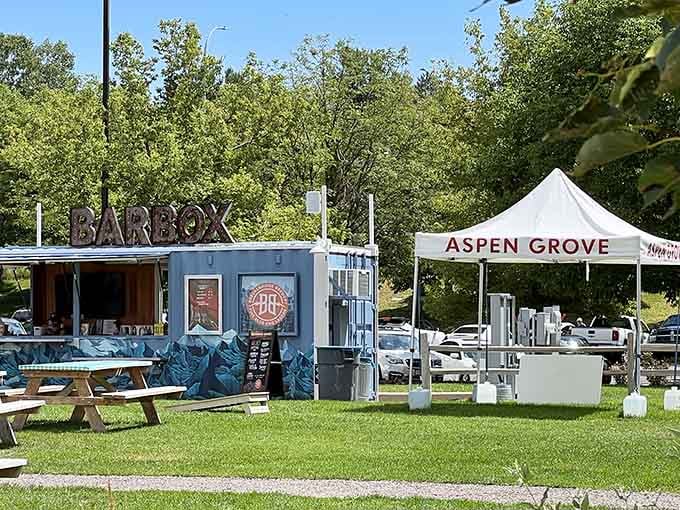 White tents and green grass create a European market atmosphere where artisans gather beneath the trees.