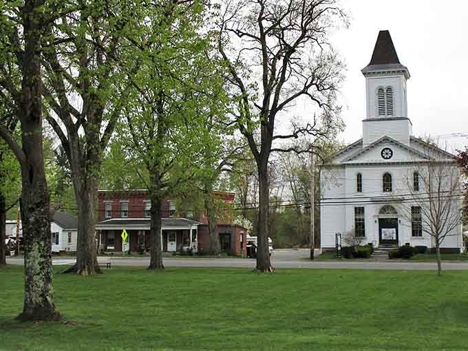 The white church anchors the town common perfectly, surrounded by ancient trees that have witnessed countless Sunday services and town meetings.