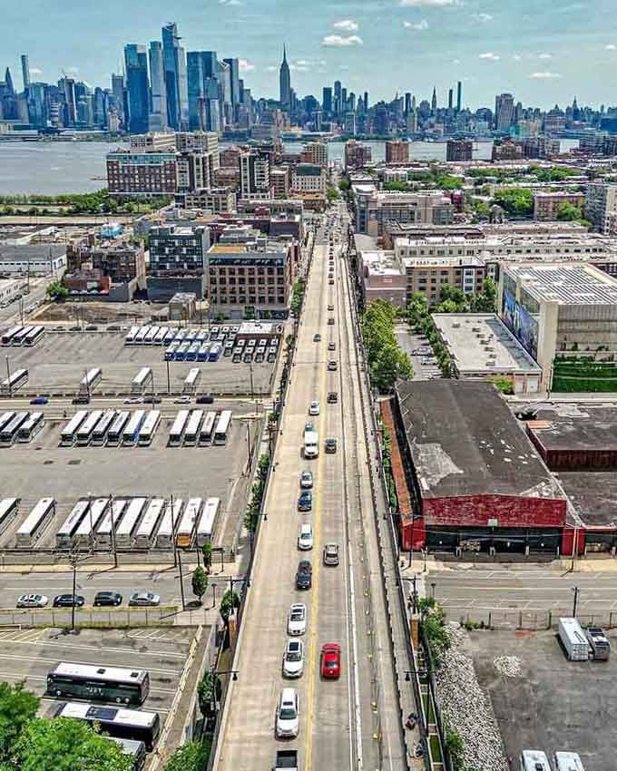 This bird's-eye view shows urban renewal in action, where industrial grit meets Manhattan's glittering skyline across the water.