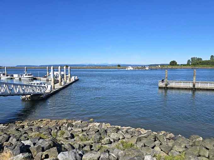 Marina docks stretch across calm waters where mountains stand guard like patient giants watching over their watery kingdom.