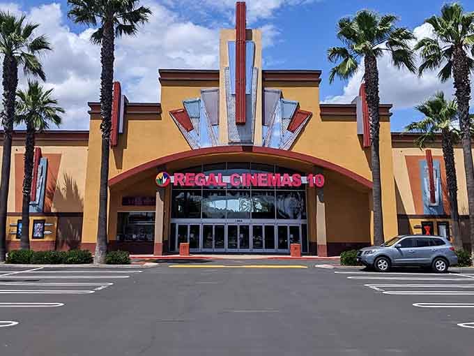 Art Deco details crown this cinema entrance, flanked by palms that sway in the desert breeze.