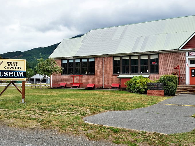 The White Pass Country Museum stands proudly, a brick time capsule where local history comes alive beneath those iconic red benches.