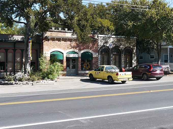 Dappled sunlight through ancient oaks frames storefronts that have weathered generations with grace and character intact.