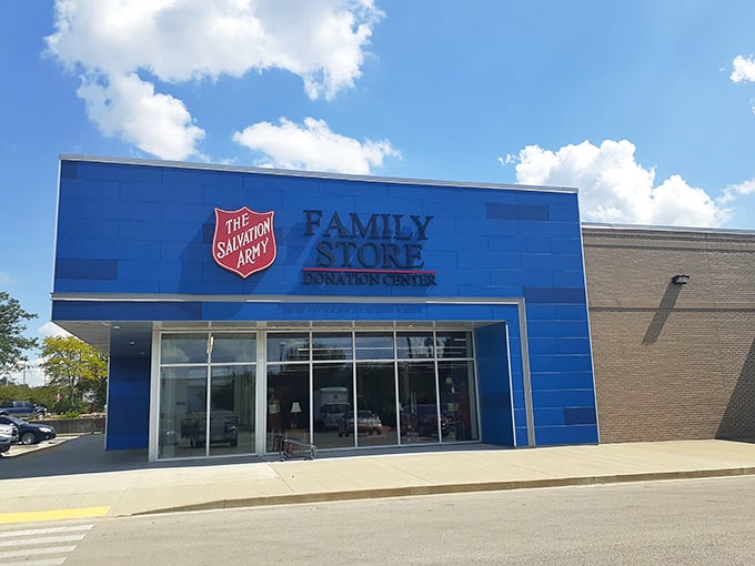 The iconic Salvation Army shield stands proud against blue siding and puffy clouds, marking this beloved community treasure spot.