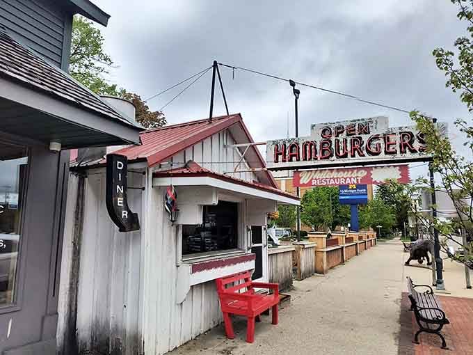 That vintage "OPEN" sign glowing above the tiny white building is basically a beacon of hope for hungry souls.