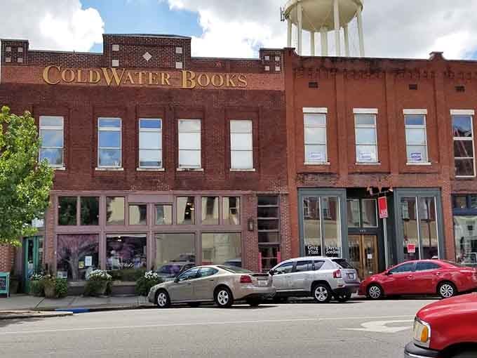 That iconic water tower peeks above Coldwater Books, where literary treasures await inside weathered brick walls.