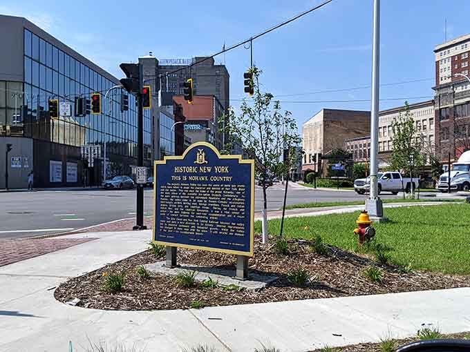 The historic marker tells tales of Haudenosaunee heritage while modern buildings prove progress respects the past around here.