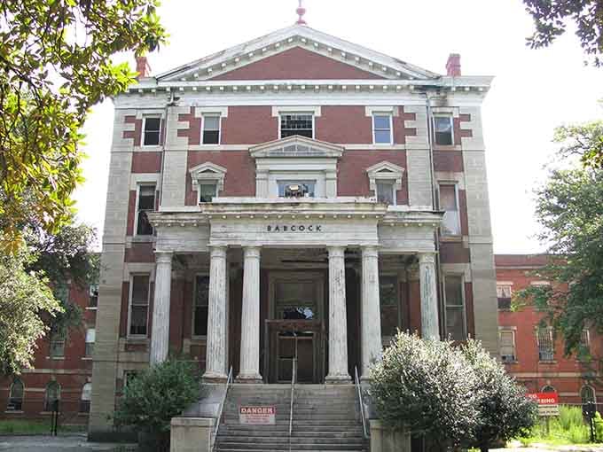 Sunlight on brick and stone creates an almost cheerful facade, though those empty windows suggest otherwise to observant visitors.