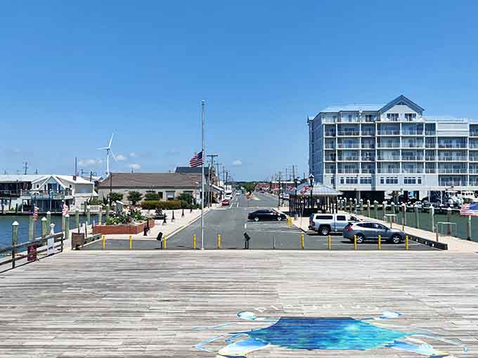 The boardwalk extends toward blue skies where street art adds whimsy to practical infrastructure along the water.