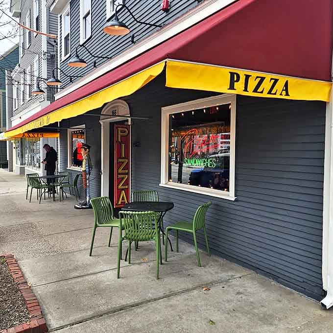 That cheerful blue building with outdoor seating says "life's too short for boring pizza experiences."