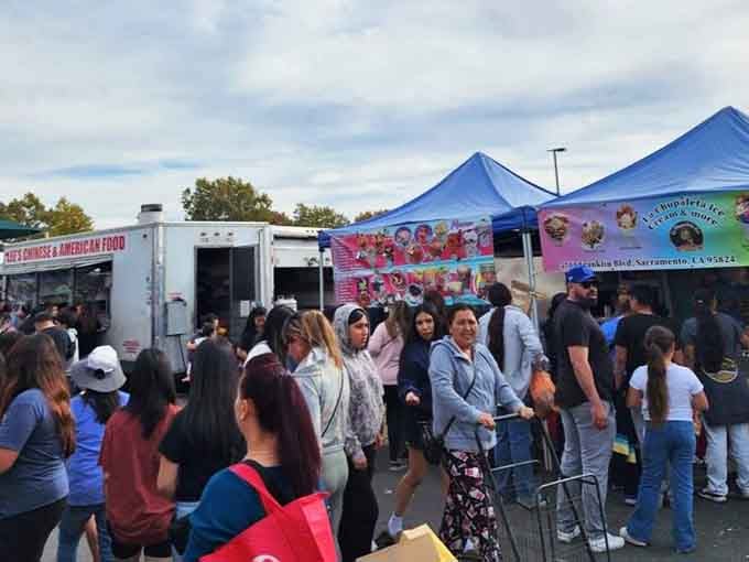 Food trucks draw hungry crowds while bright tents shelter everything from clothing to collectibles under the warm sun.