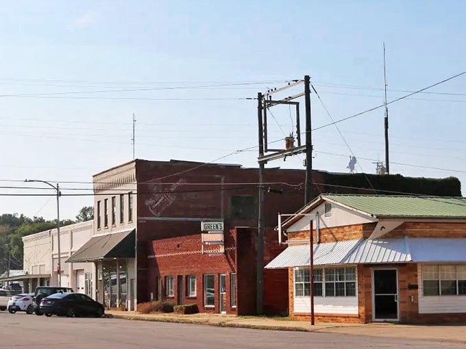 Red brick storefronts line streets where mountains rise in the distance like nature's own welcome sign to town.