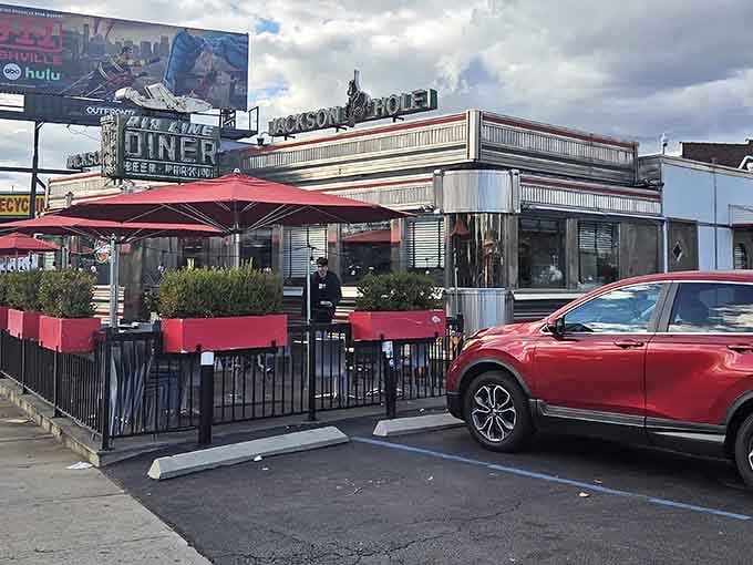 The red patio umbrellas at Jackson Hole Diner stand guard like cheerful sentinels, protecting diners from both sun and rain while they tackle those famous burgers.