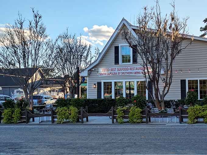 This classic white building with blue shutters looks like it stepped right out of a postcard about perfect Southern seafood spots.