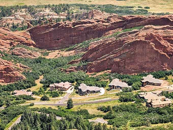 Red rock amphitheater cradles the visitor center below, proving that even parking lots can have million-dollar mountain views here.