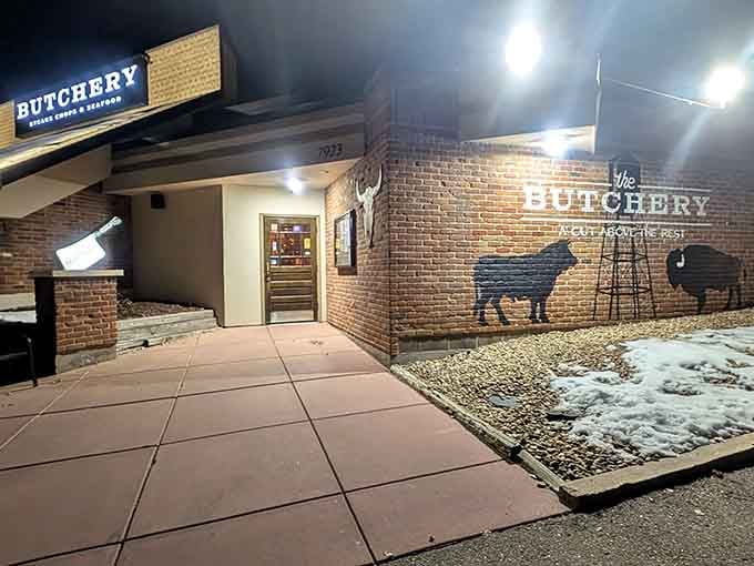Evening lighting transforms the brick facade into something magical, while those painted cattle silhouettes celebrate what's cooking inside tonight.
