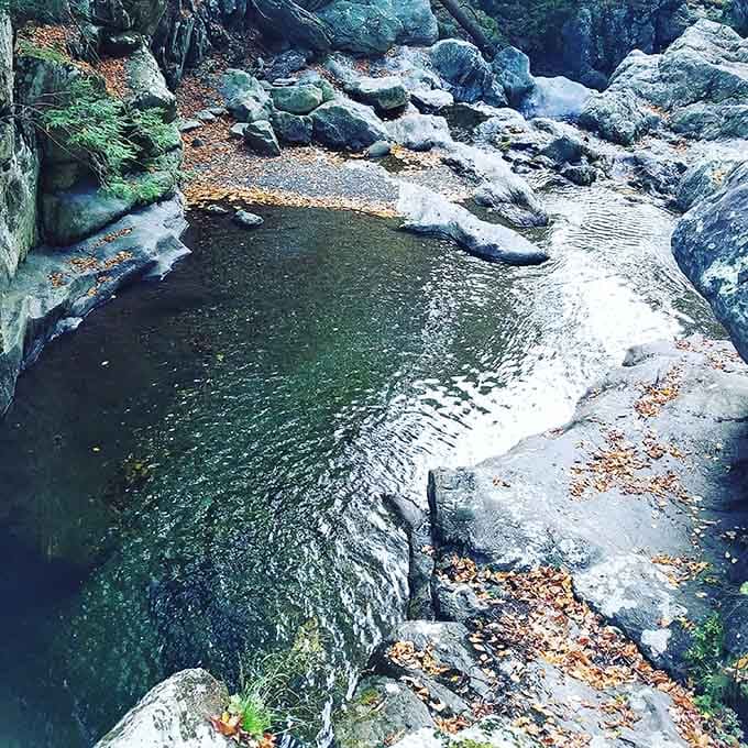 That emerald pool at the base isn't just pretty, it's cold enough to make you reconsider every life choice instantly.