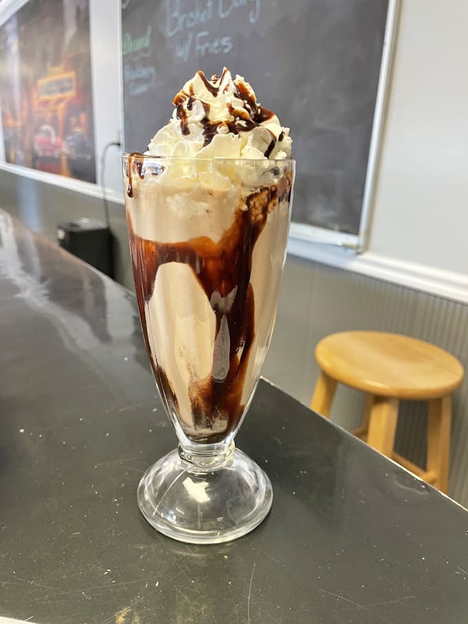 That towering milkshake with chocolate drizzle and whipped cream looks like it escaped from a 1950s soda fountain fantasy.