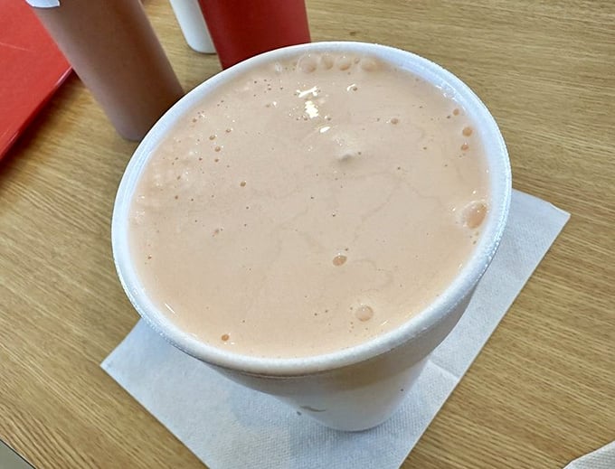 A creamy orange milkshake that tastes like childhood memories mixed with pure happiness in a cup.
