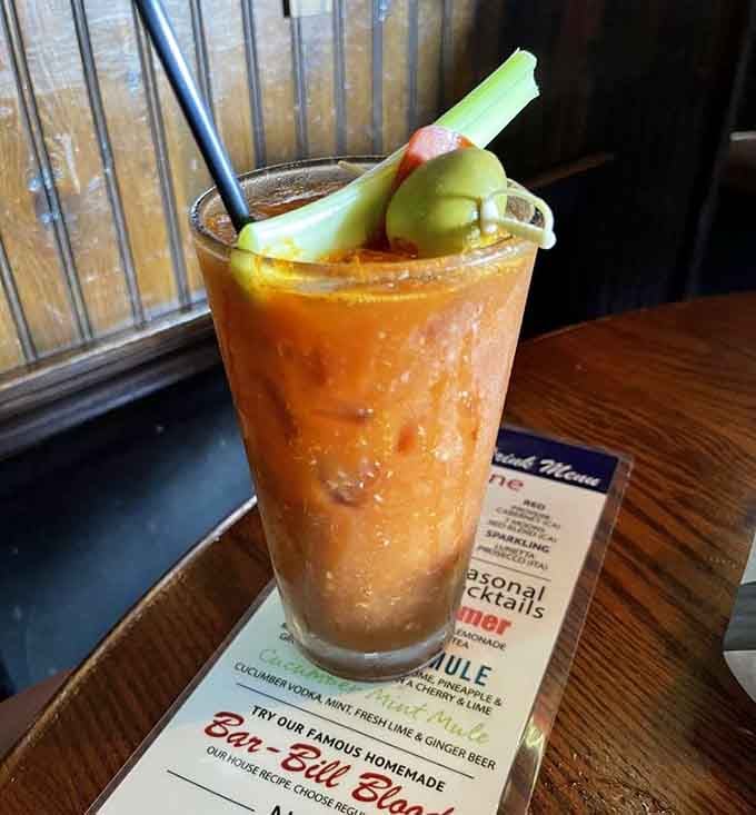 A Bloody Mary garnished with pickles and celery proves brunch drinks can be both beverage and appetizer simultaneously.