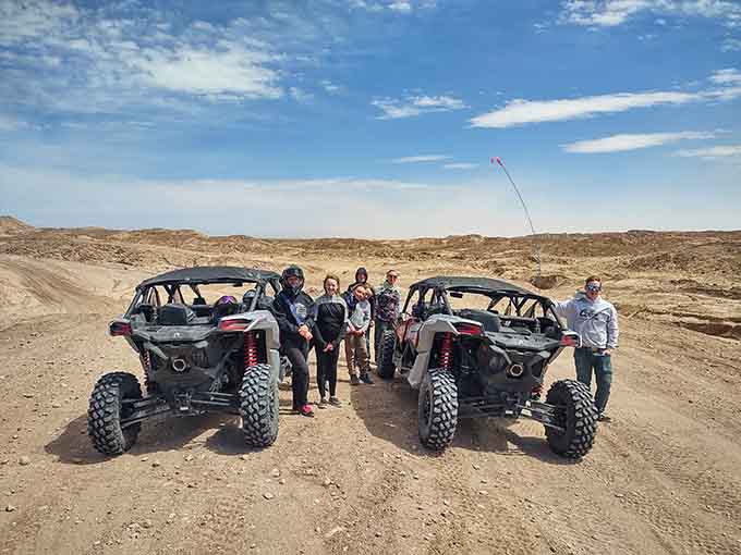 Desert adventurers pose with their off-road vehicles like proud parents at graduation, and honestly, they've earned it.